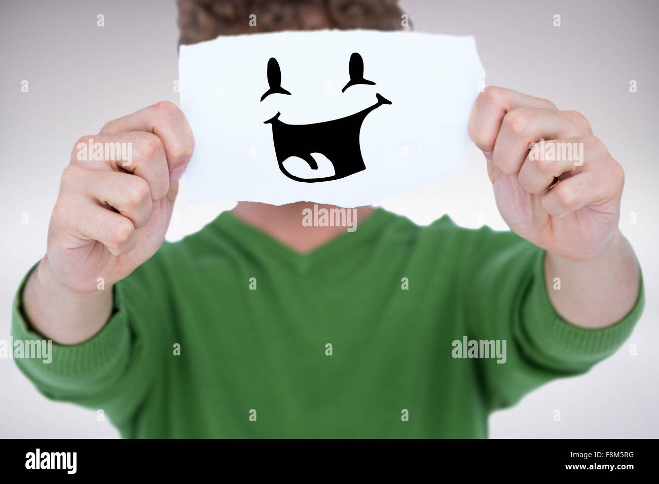 Composite image of man holding blank paper in front on face Stock Photo ...