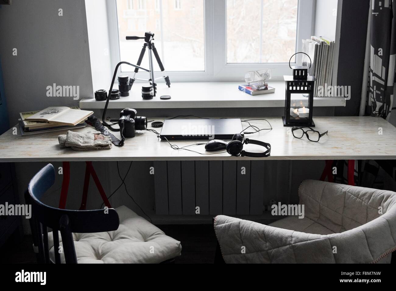 Desk with closed laptop and two chairs Stock Photo - Alamy