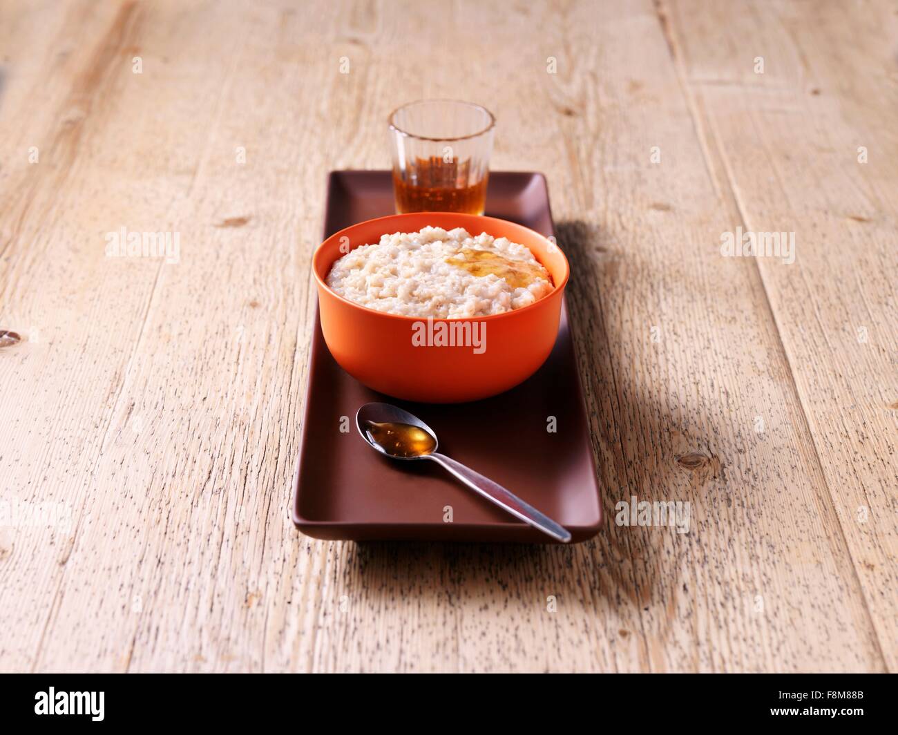 Breakfast bowl of porridge with honey on wood Stock Photo - Alamy