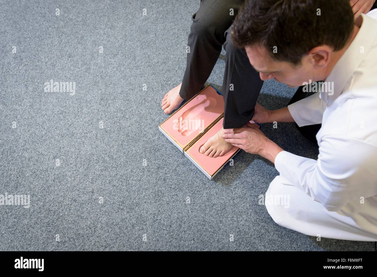 Making a foot imprint mould for orthopaedic foot support Stock Photo ...