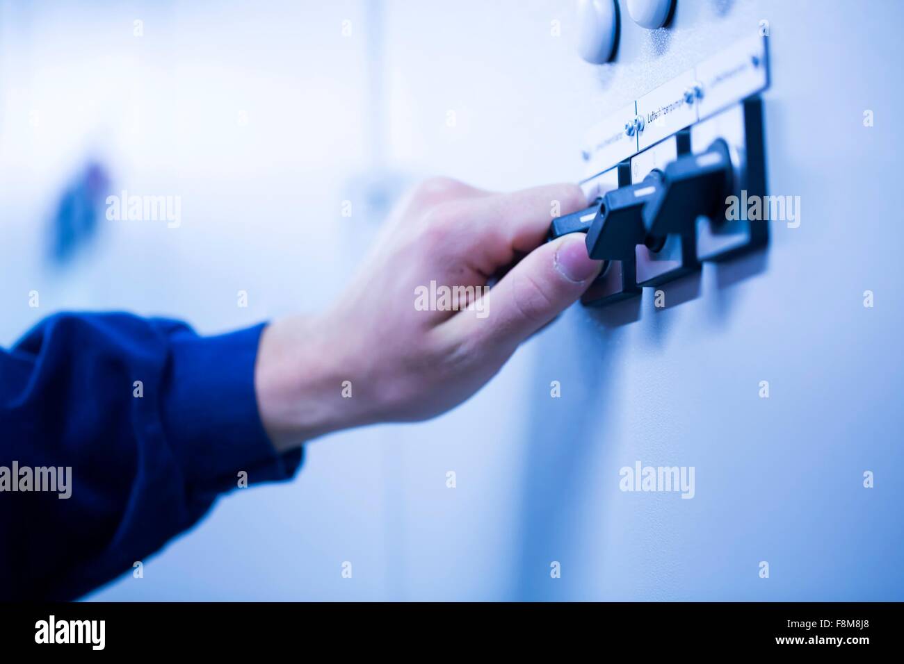 Cropped view of young mans hand adjusting dial on switchgear Stock ...