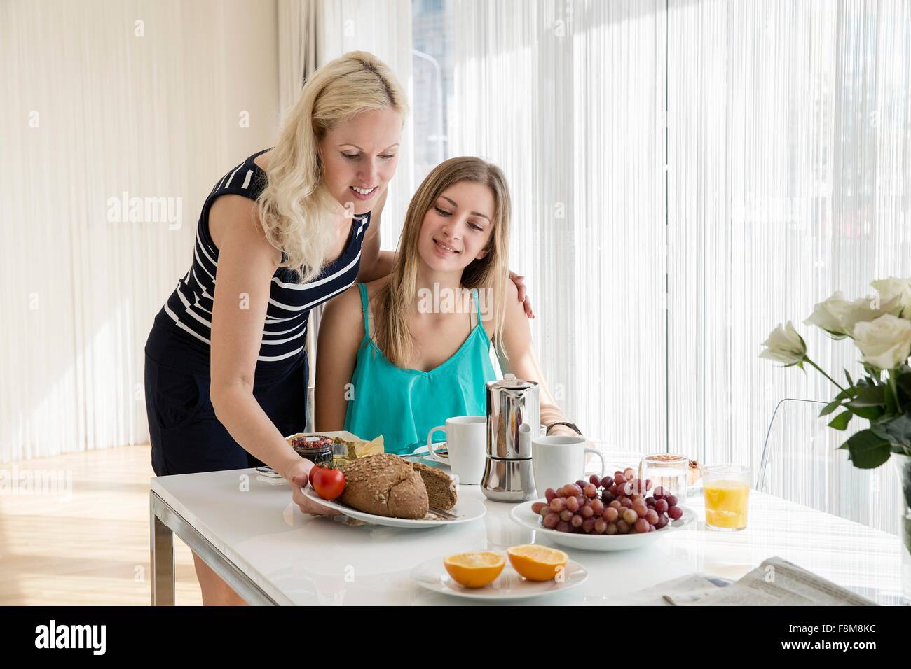 Woman serving friend continental breakfast Stock Photo - Alamy