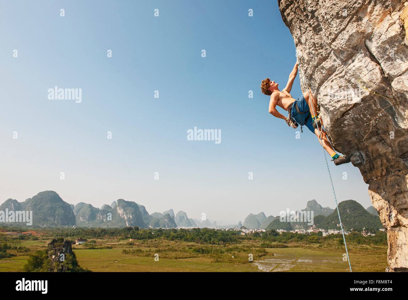 Male climber climbing on the Egg - a limestone cliff in Yangshuo ...