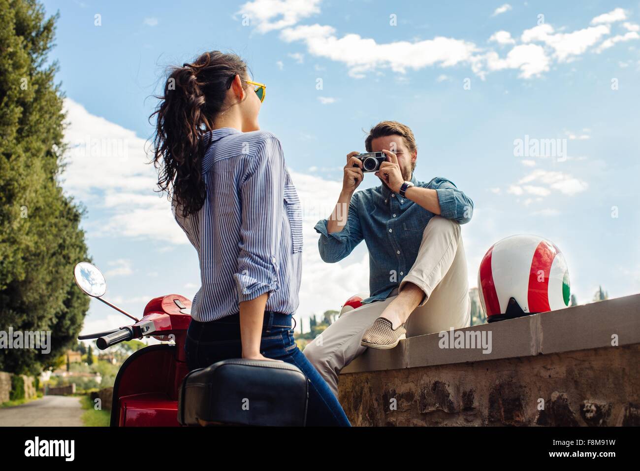 Young man photographing girlfriend from wall, Florence, Italy Stock ...