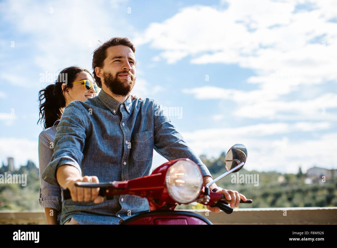 Young couple riding moped in Florence hills, Italy Stock Photo - Alamy