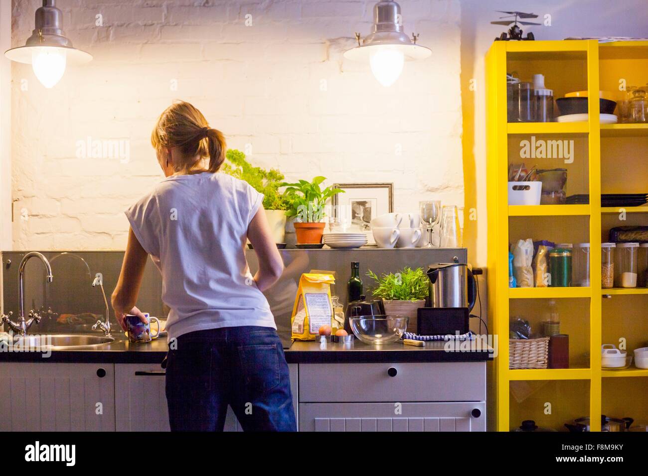 Rear view of mid adult woman preparing to bake at kitchen counter Stock ...