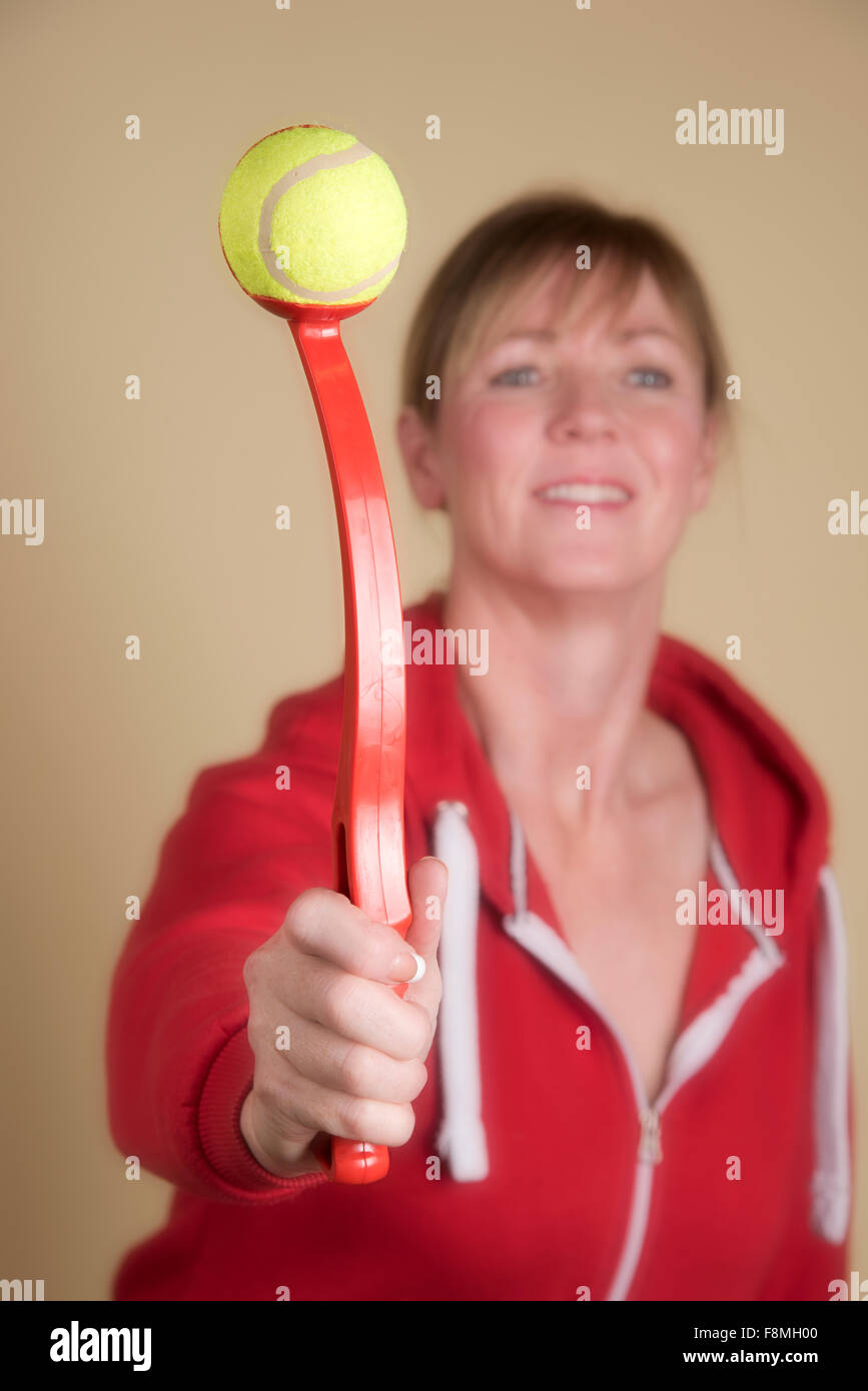 Woman's hand holding a tennis ball launcher used for throwing the ball ...