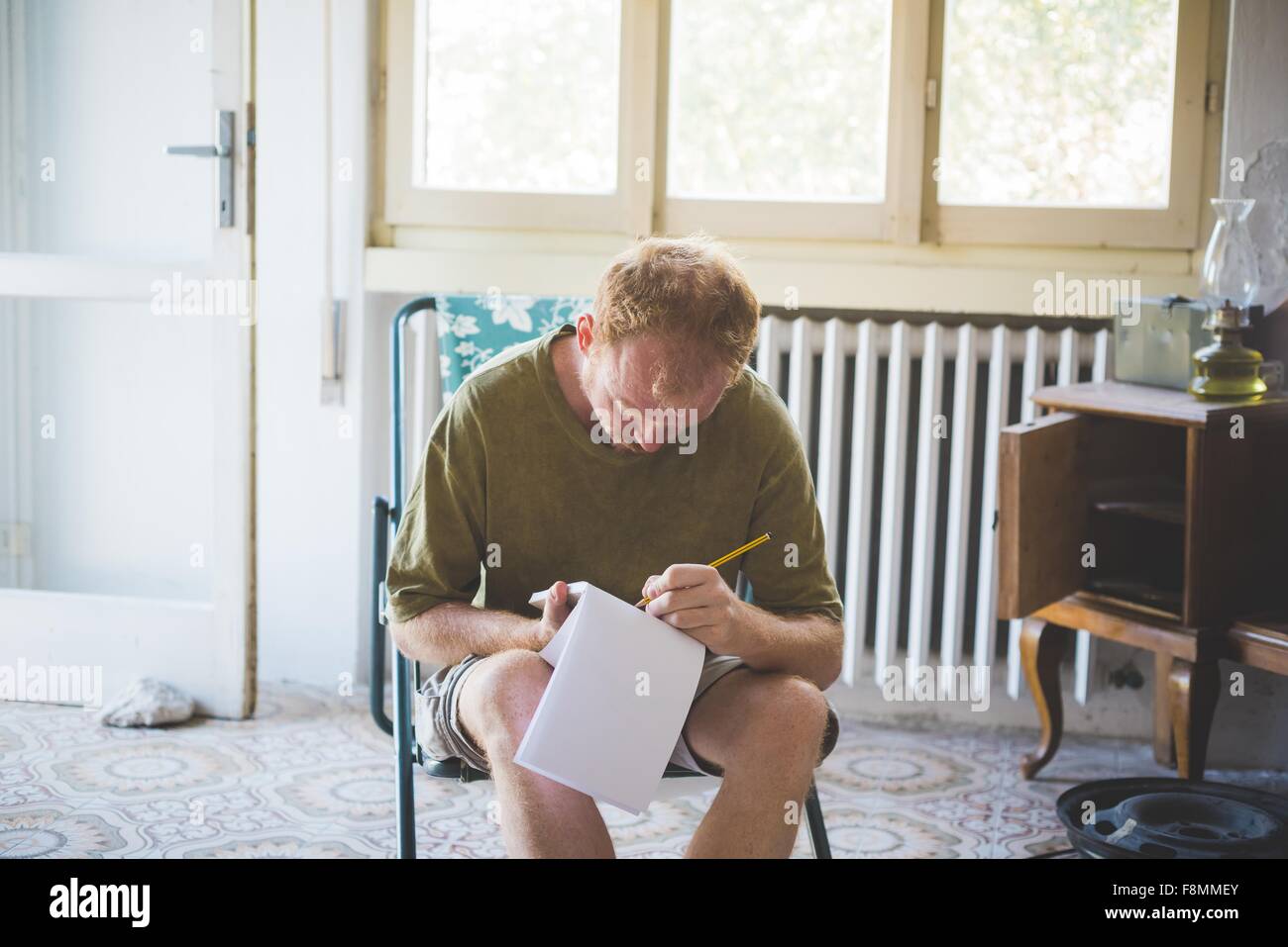 Man writing notes in room Stock Photo - Alamy