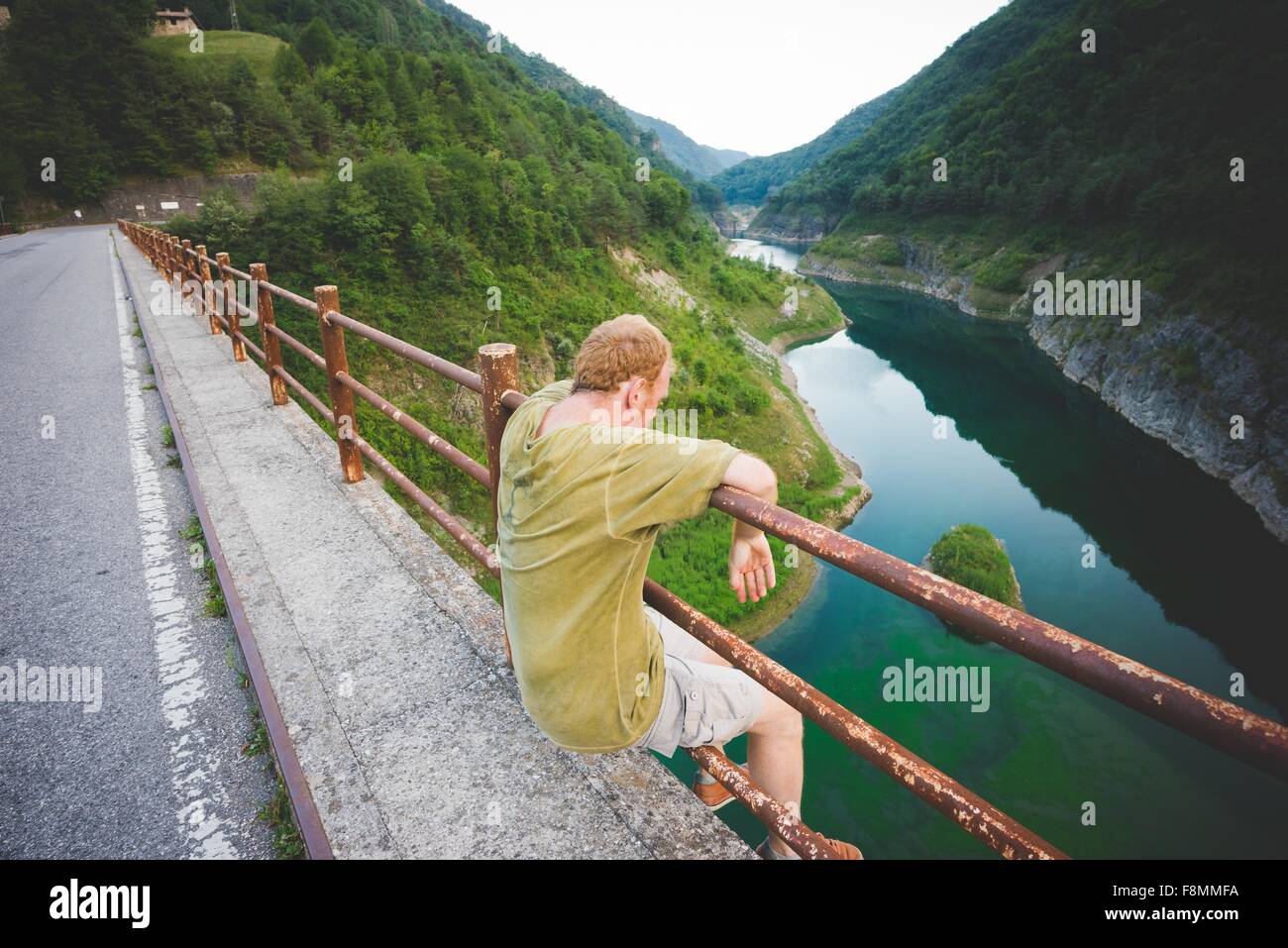 Man sitting on railing hi-res stock photography and images - Alamy