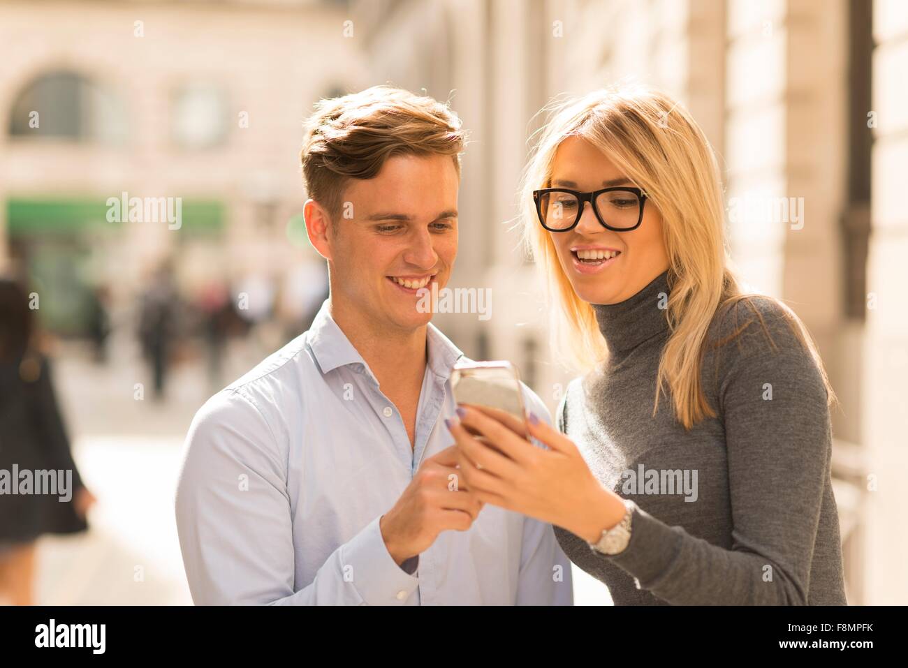 Couple sharing text message in street Stock Photo - Alamy