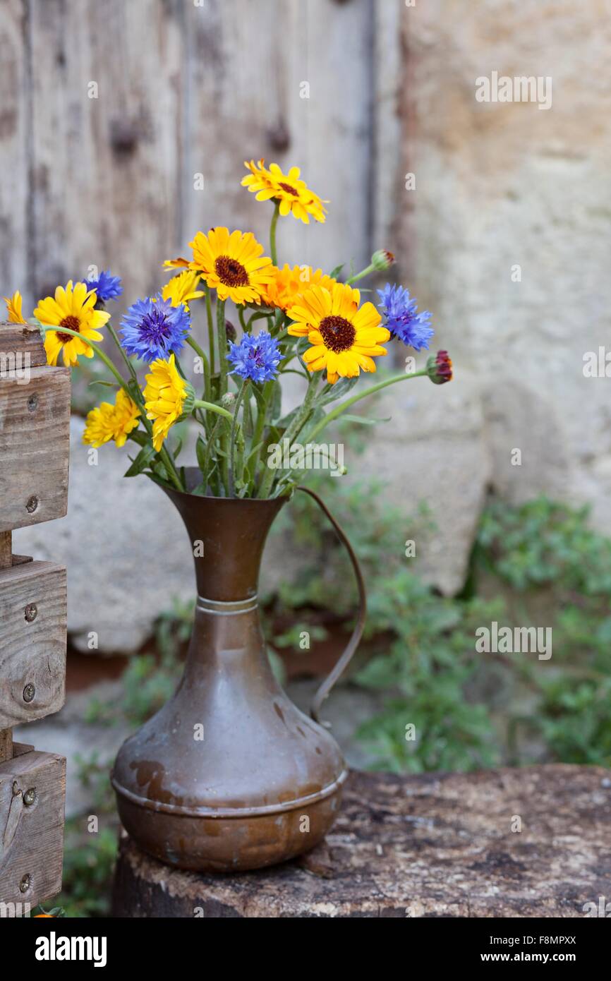 Fresh flowers in metal jug, outdoors Stock Photo - Alamy
