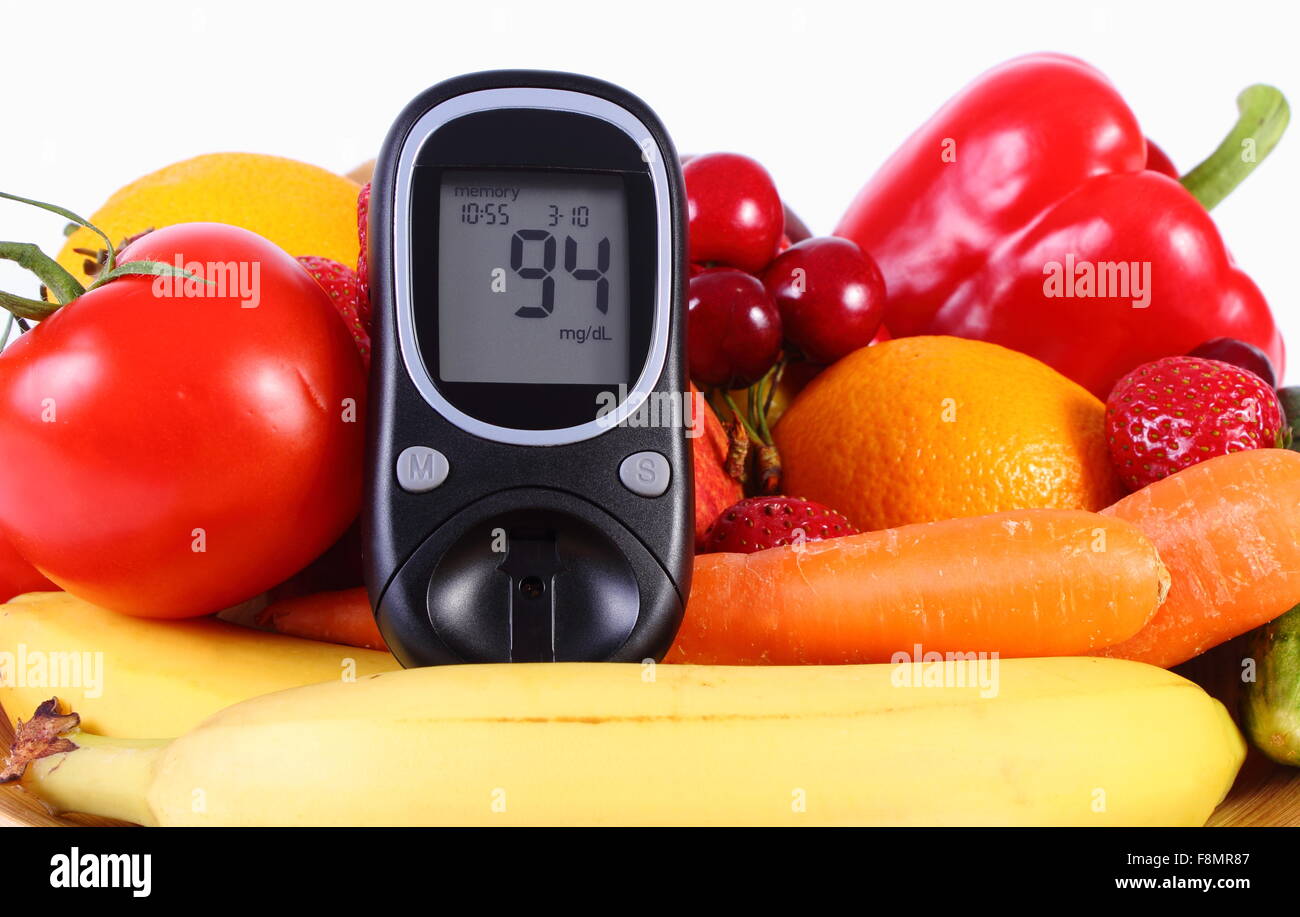 Glucometer with fresh ripe fruits and vegetables lying on wooden plate ...