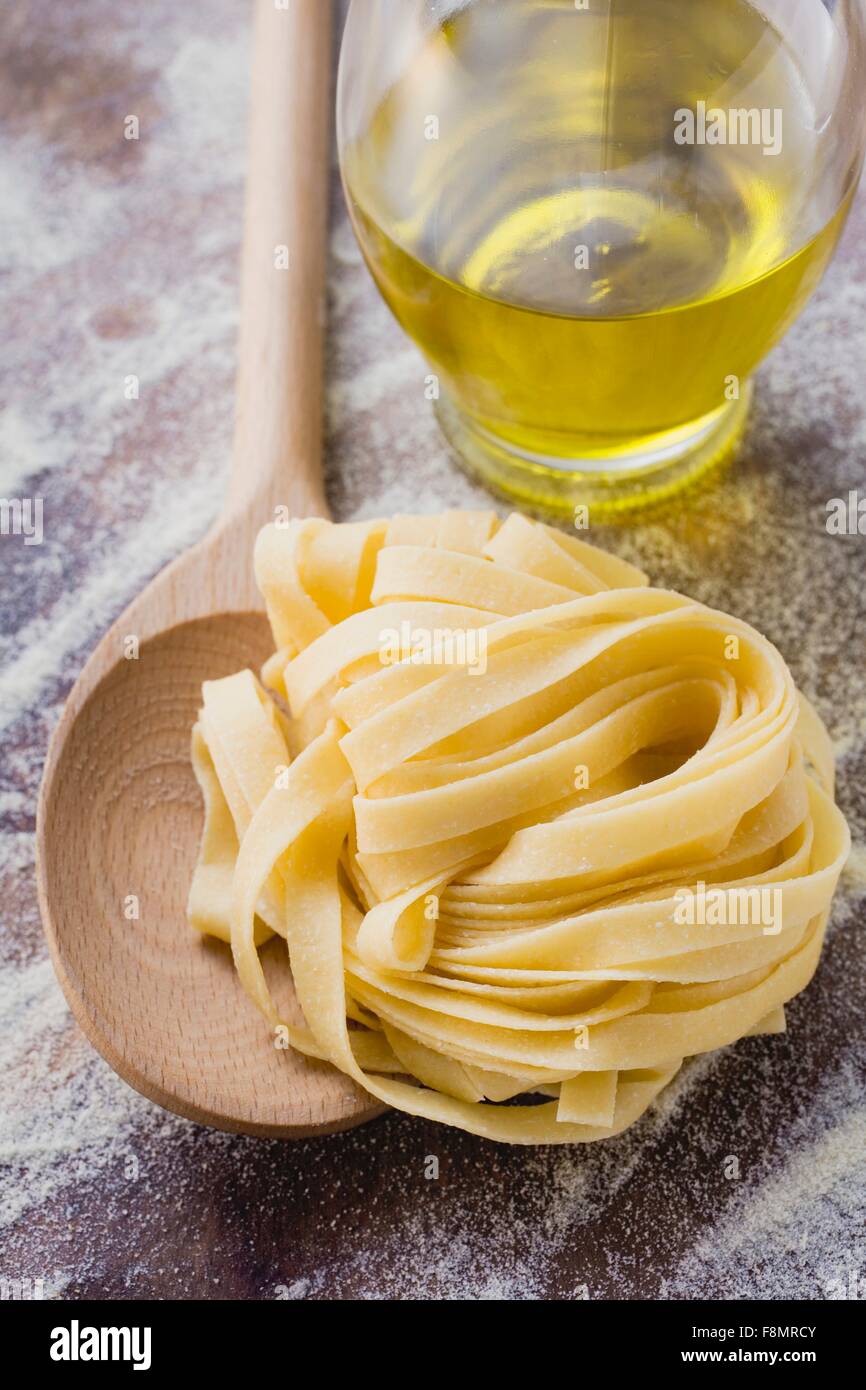 Home-made ribbon pasta with wooden spoon and olive oil Stock Photo - Alamy
