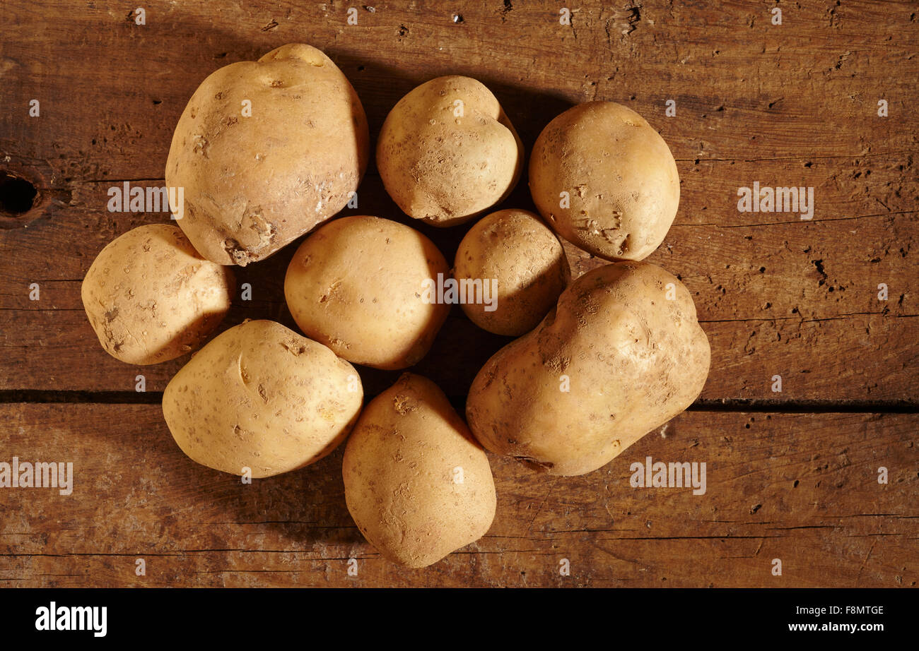 whole potatoes on a wood background Stock Photo - Alamy