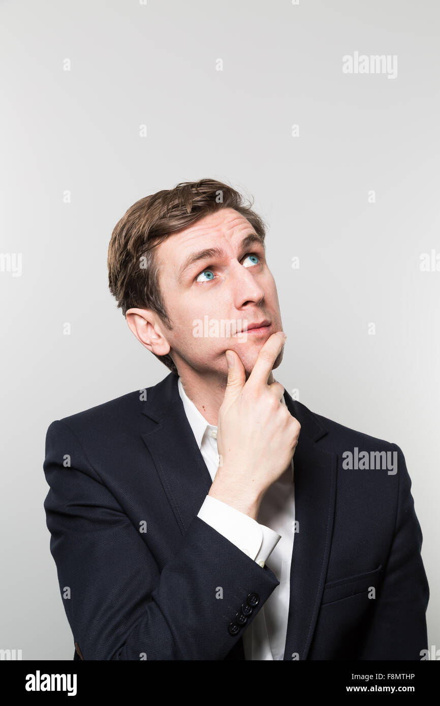 Blond-haired european businessman with a glance stares at the ceiling ...