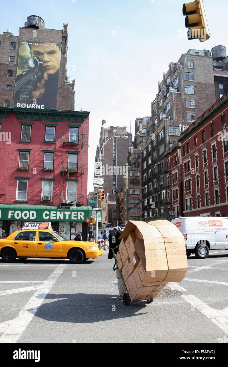 A view of a man hauling a trolley with cardboard boxes across the ...