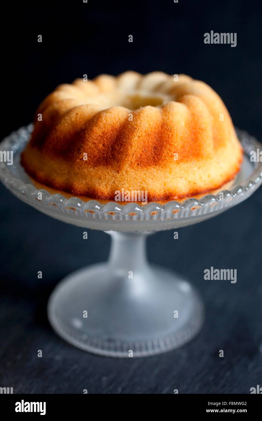 Mini lemon sponge bundt cake on vintage glass cake stand Stock Photo ...