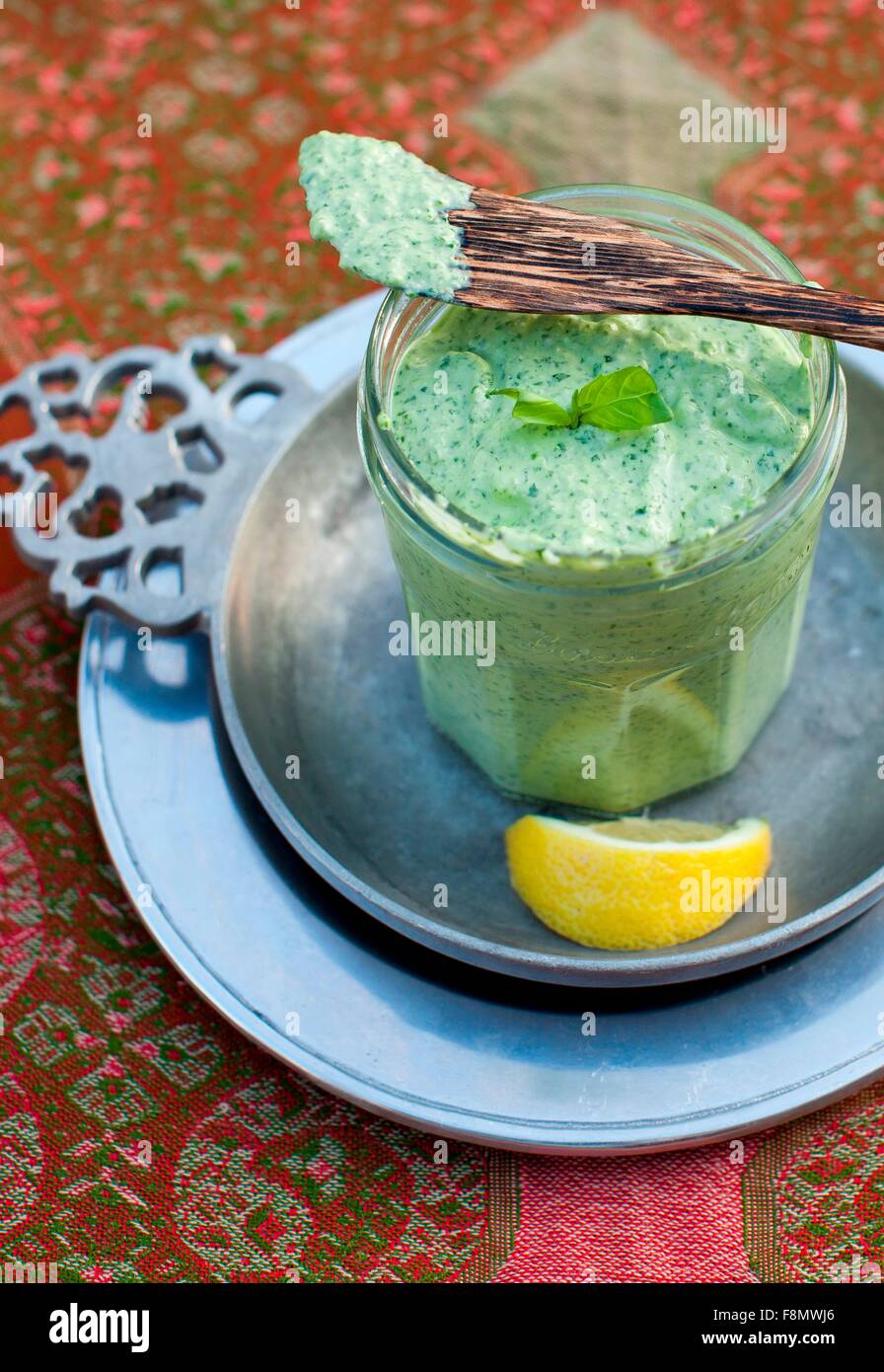 An Open Jar of Herbed Sauce with a Wooden Knife; Lemon Wedge Stock ...