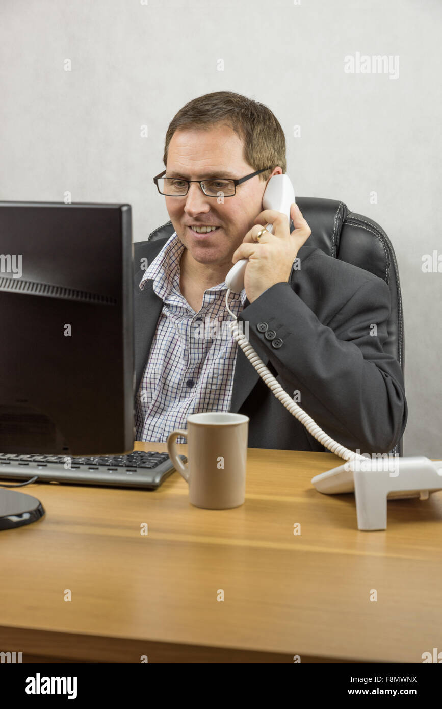 A man working at his computer in the office Stock Photo - Alamy