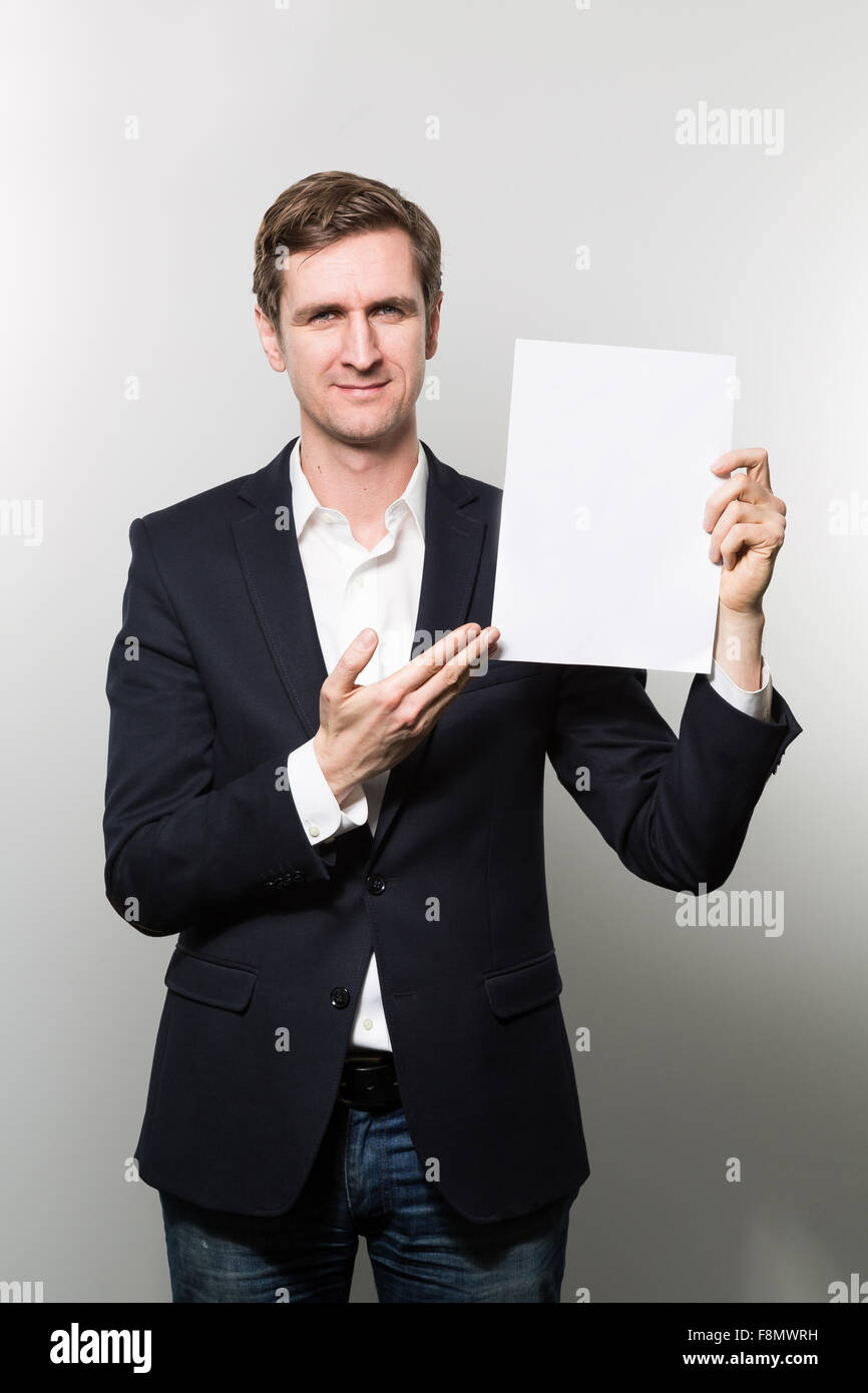 Blond-haired european businessman shows something on a piece of paper ...