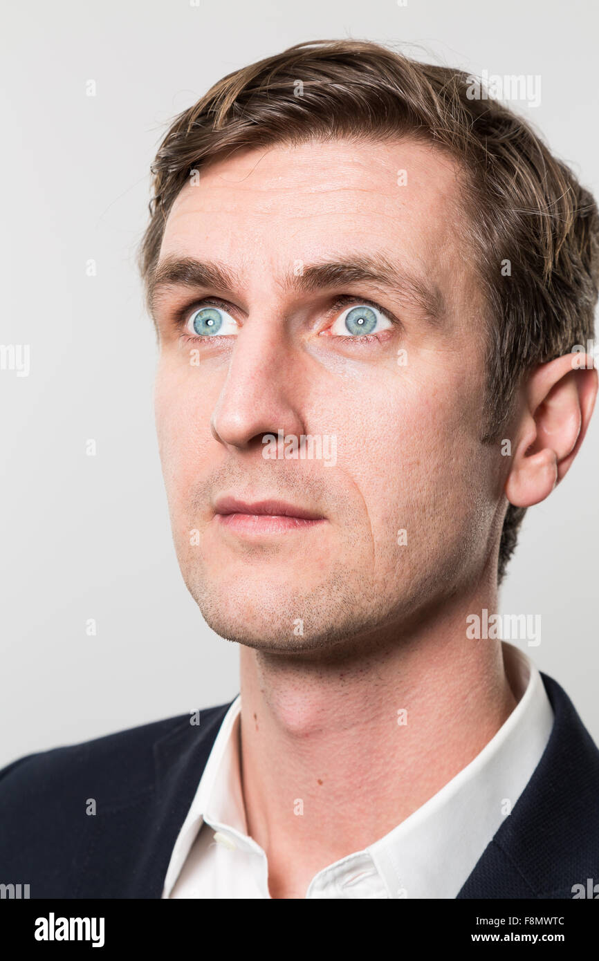 Close up of a blond-haired european businessman with a pondering stare ...