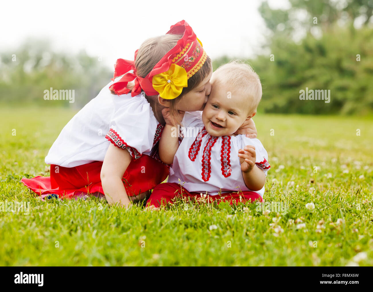 Two happy children in russian folk clothes on grass in summer Stock ...