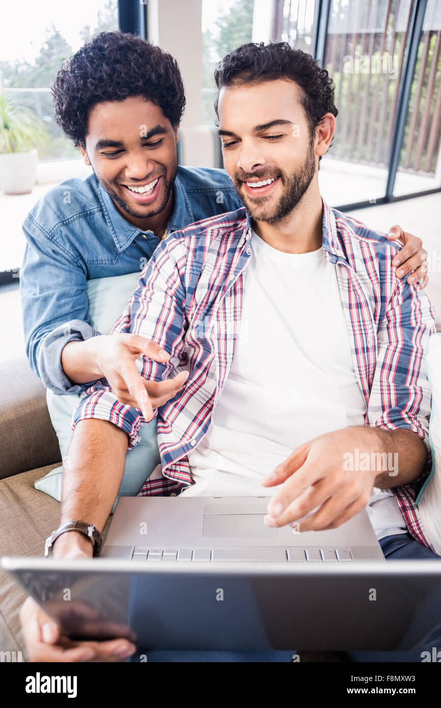Happy gay couple using laptop hi-res stock photography and images - Alamy