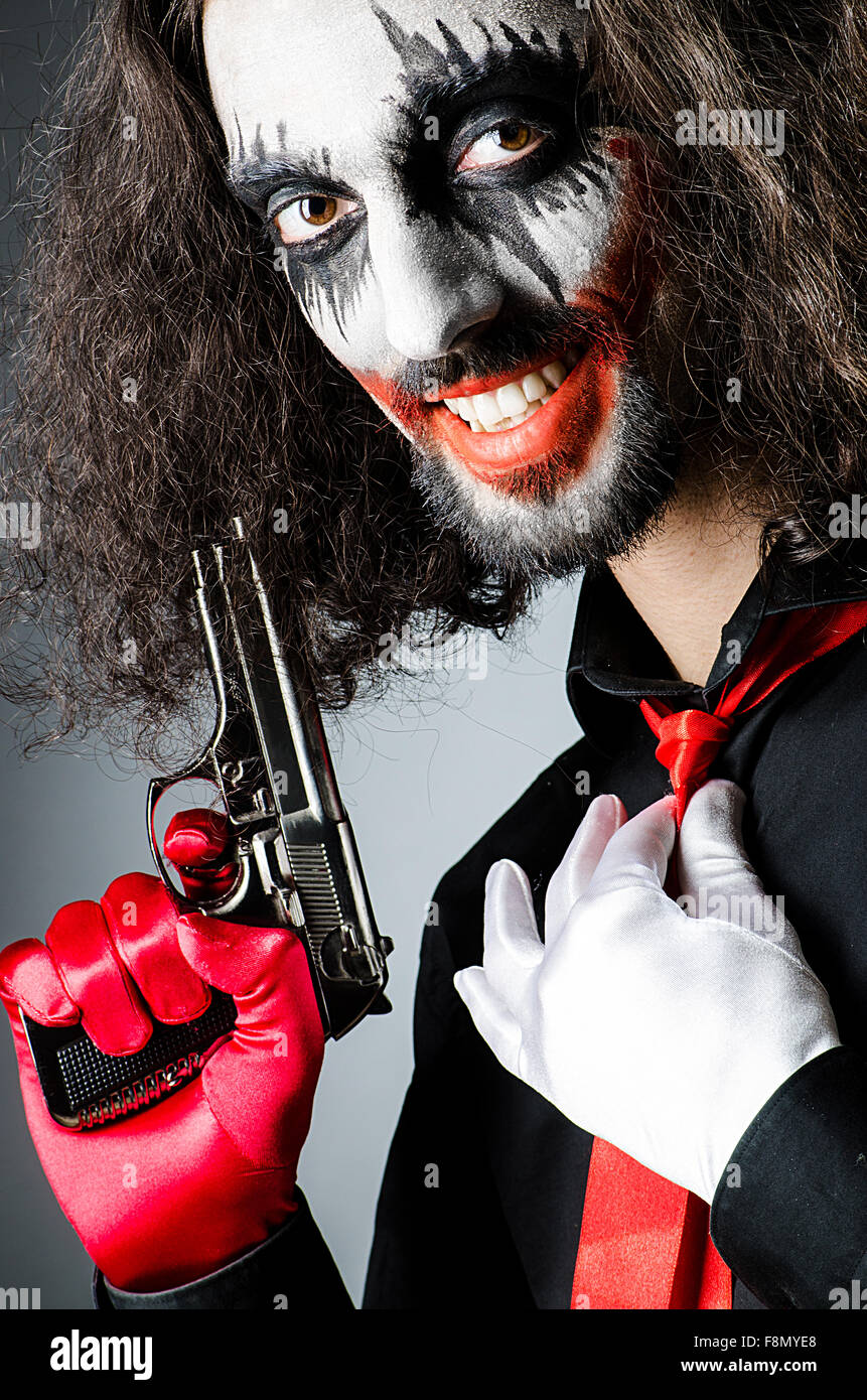 Evil clown with gun in dark room Stock Photo - Alamy