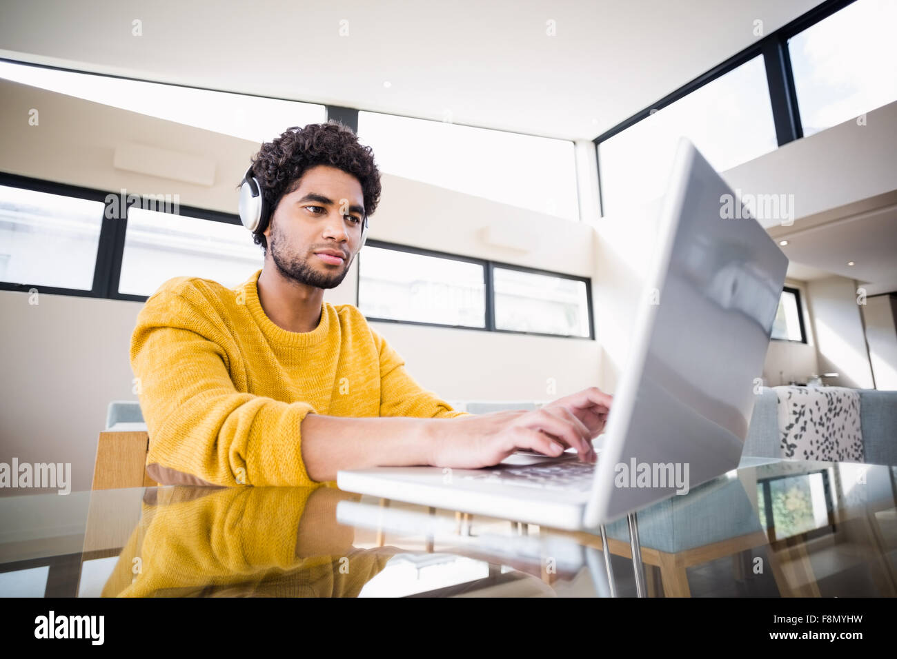 Attractive man using headphones and laptop Stock Photo - Alamy