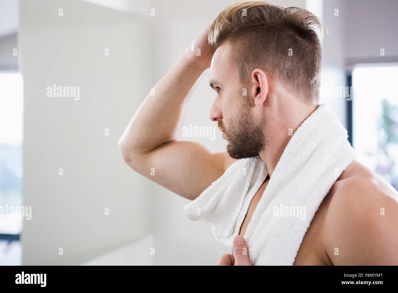 Handsome man looking in mirror Stock Photo - Alamy