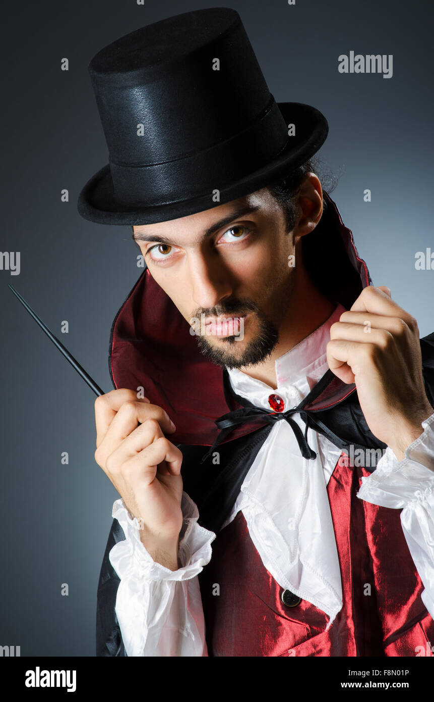 Magician doing tricks in dark room Stock Photo - Alamy