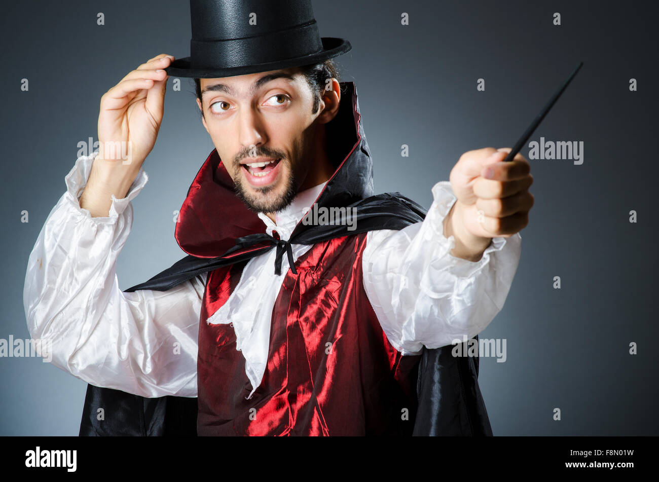 Magician doing tricks in dark room Stock Photo - Alamy