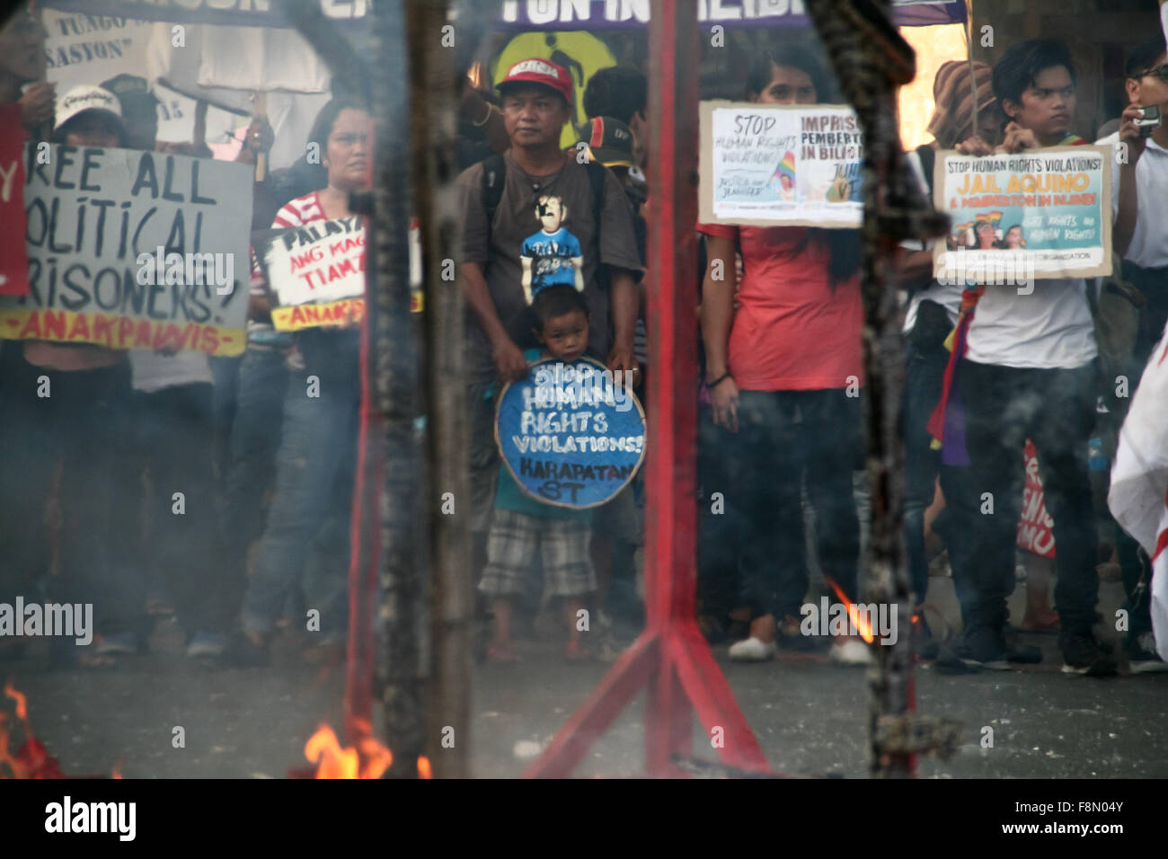 Philippines. 10th Dec, 2015. Protesters stand around the burnt effigy ...