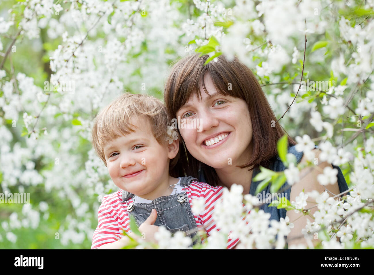 Happy mother with toddler in spring garden Stock Photo - Alamy