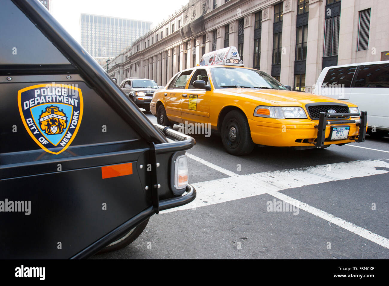 Yellow cab on the West 33 street with a view of the hood of a police ...