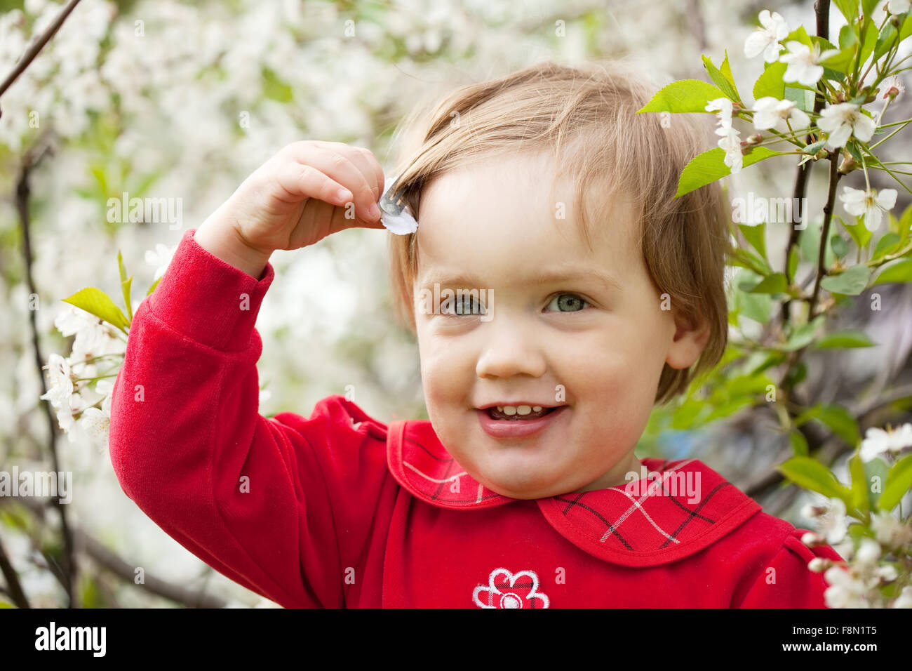 Happy baby girl in spring garden Stock Photo - Alamy