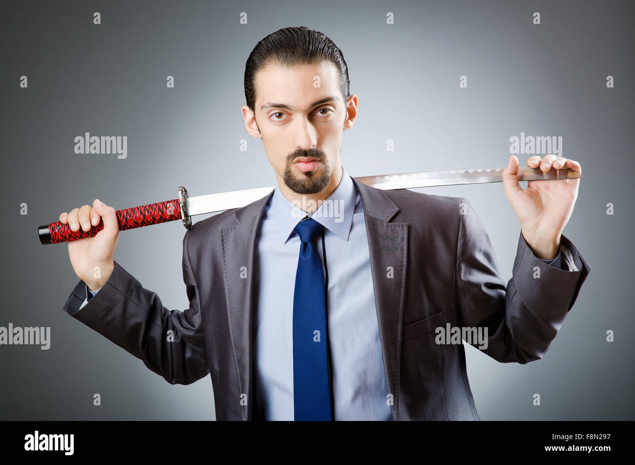 Angry businessman with sword in dark room Stock Photo - Alamy