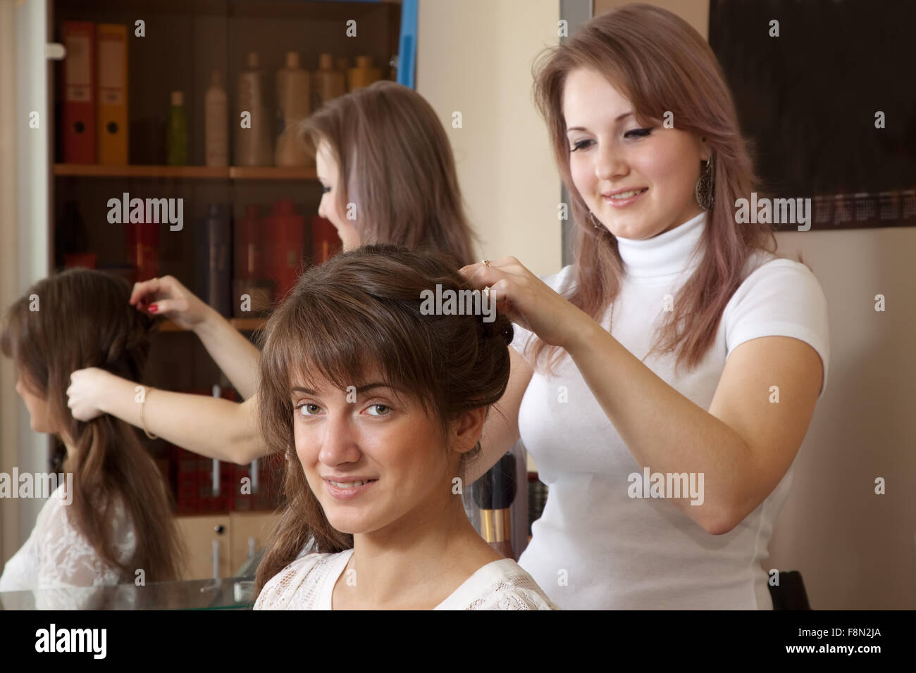 Female hairdresser works on woman hair in salon Stock Photo - Alamy