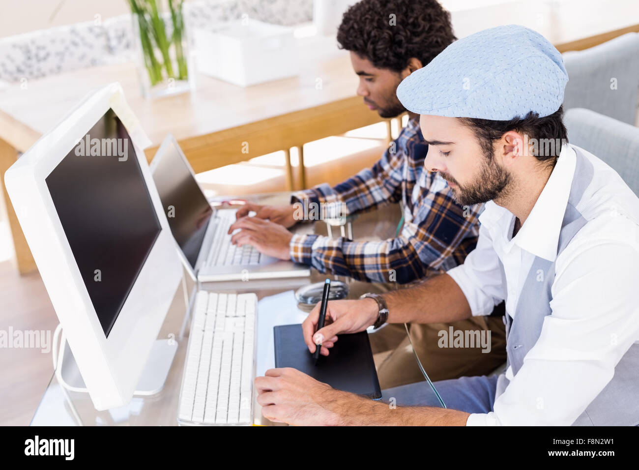 Focused gay couple working in office Stock Photo - Alamy