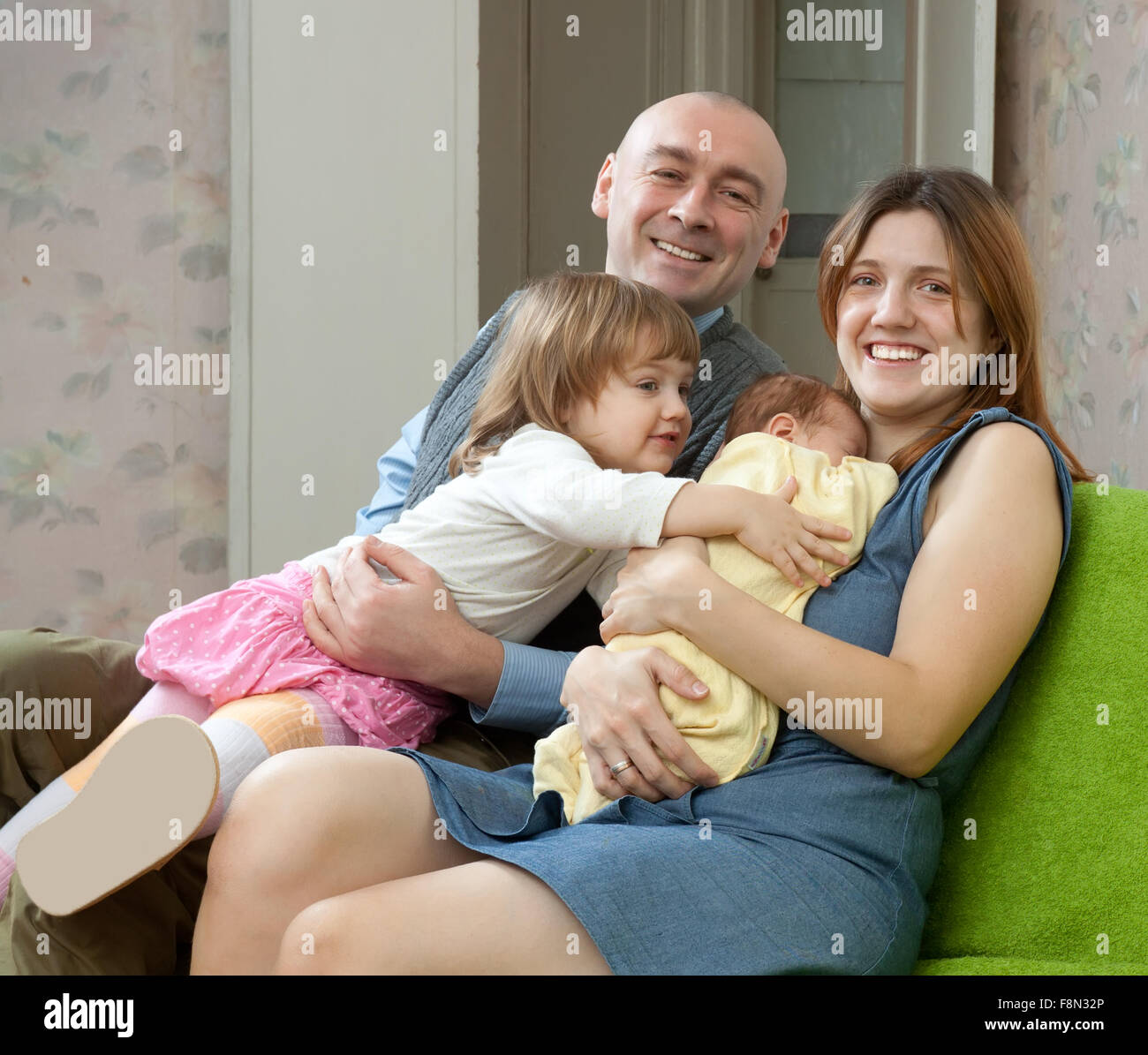 Happy parents with two children at home Stock Photo - Alamy