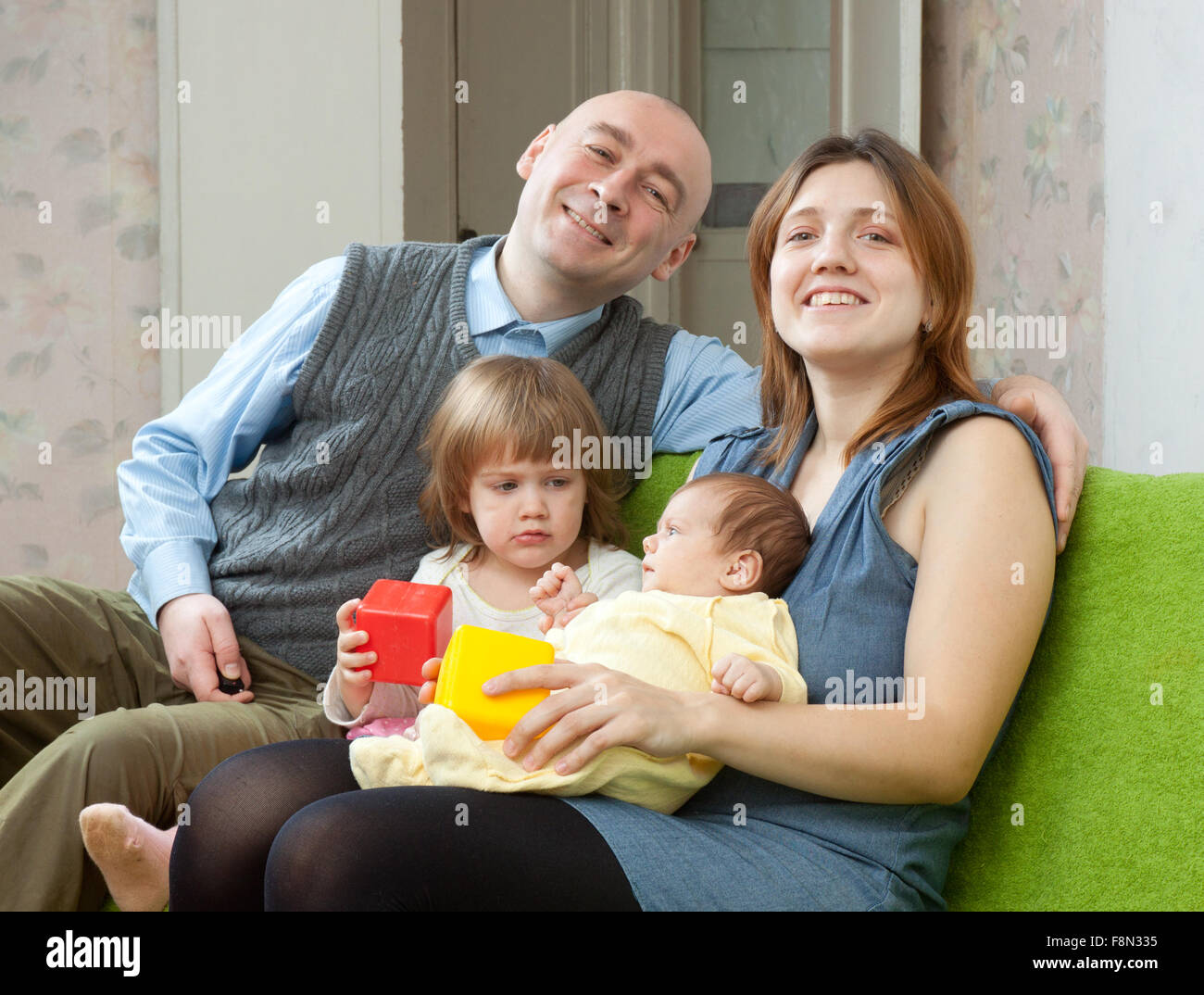 Happy family of four with newborn baby Stock Photo - Alamy