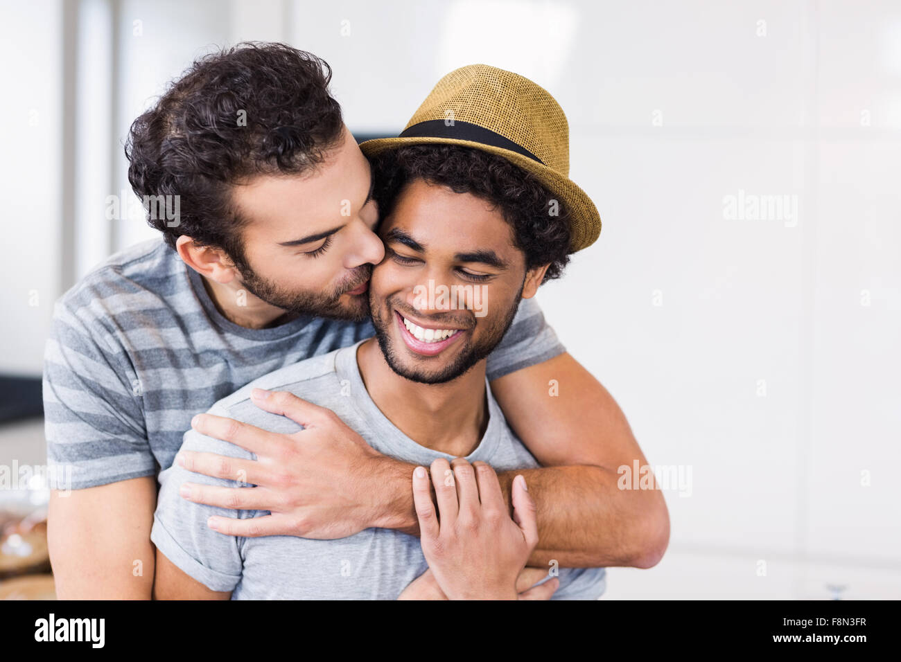 Handsome man hugging and kissing his boyfriends cheek Stock Photo - Alamy