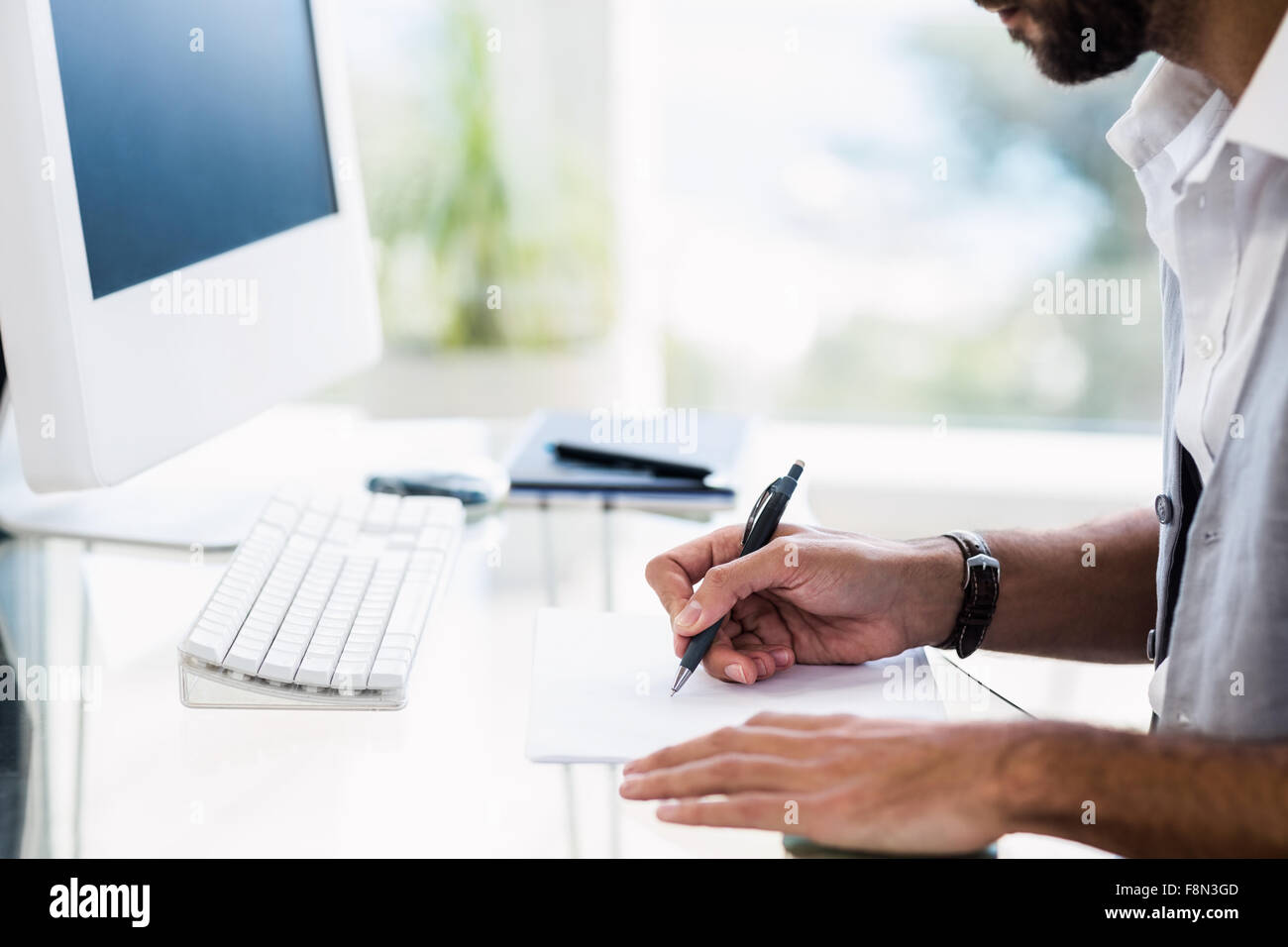 Side view of man taking notes Stock Photo - Alamy