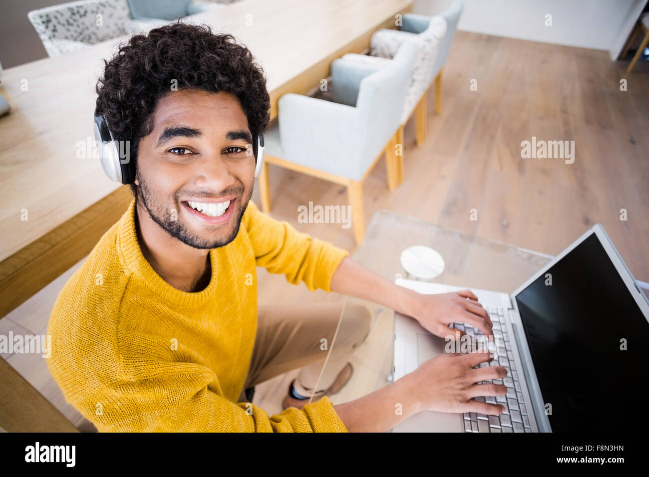 Happy man using headphones and laptop Stock Photo - Alamy