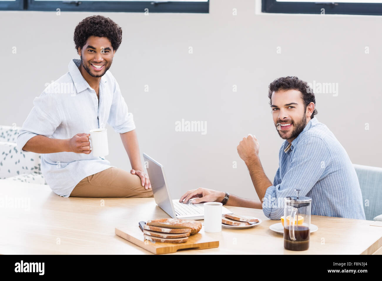Happy gay couple using laptop Stock Photo - Alamy