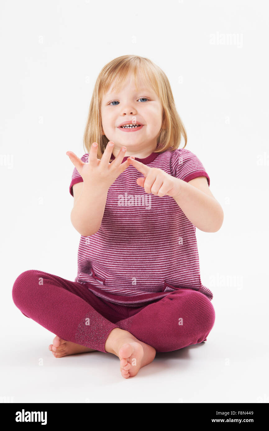 Studio Shot Of Little Girl Counting On Fingers Stock Photo - Alamy
