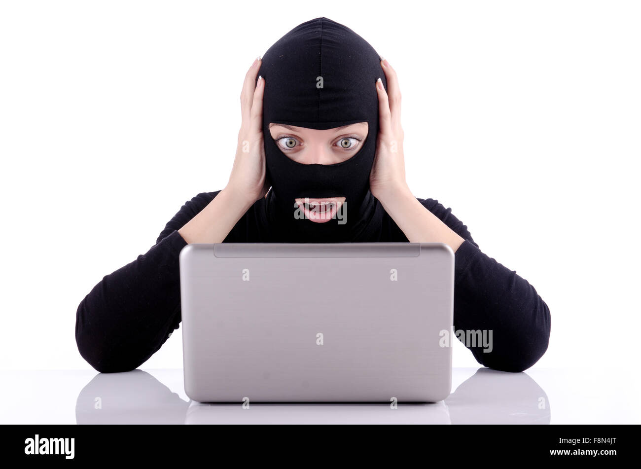 Hacker with computer wearing balaclava Stock Photo - Alamy