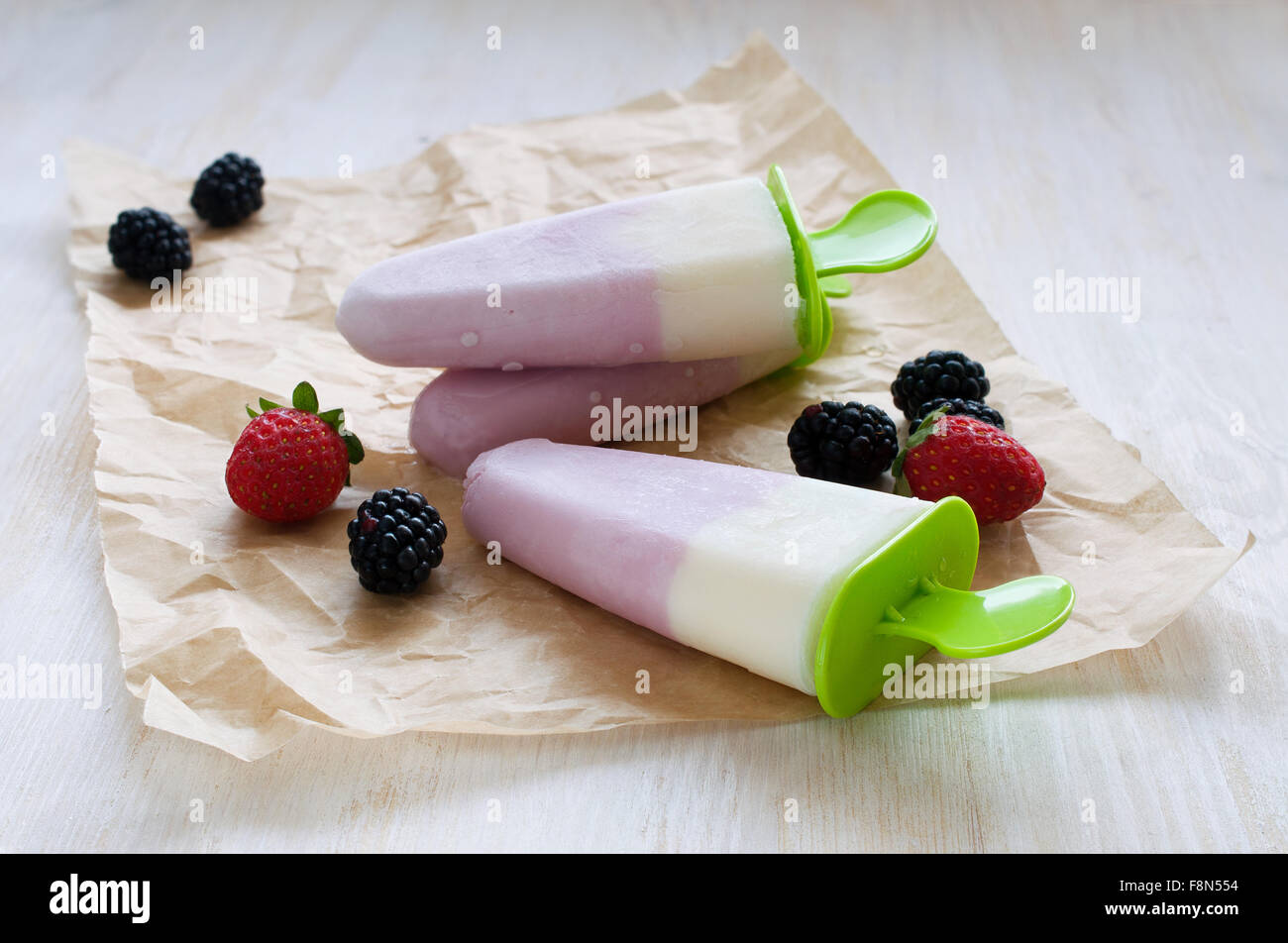 Fruit and yoghurt ice-lolly with strawberries and blackberries on a ...