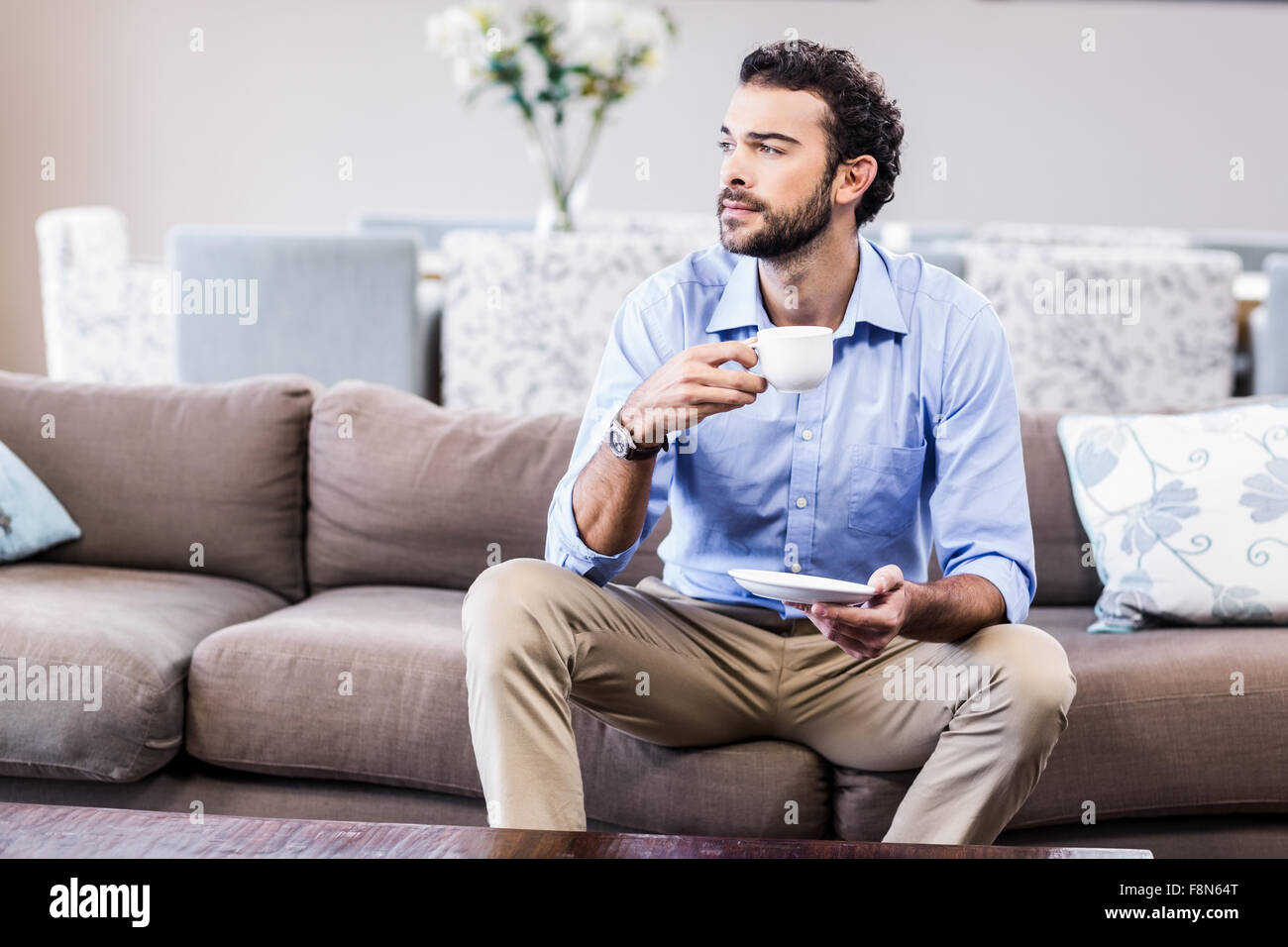 Thoughtful man holding mug looking away Stock Photo - Alamy