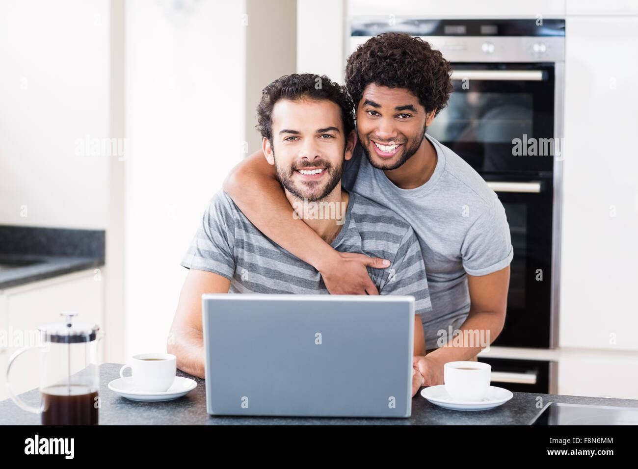 Portrait of handsome gay couple using laptop Stock Photo - Alamy